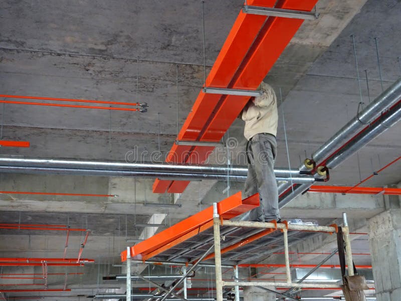 Construction Workers Installing Electrical Cable Tray and Doing Wiring ...