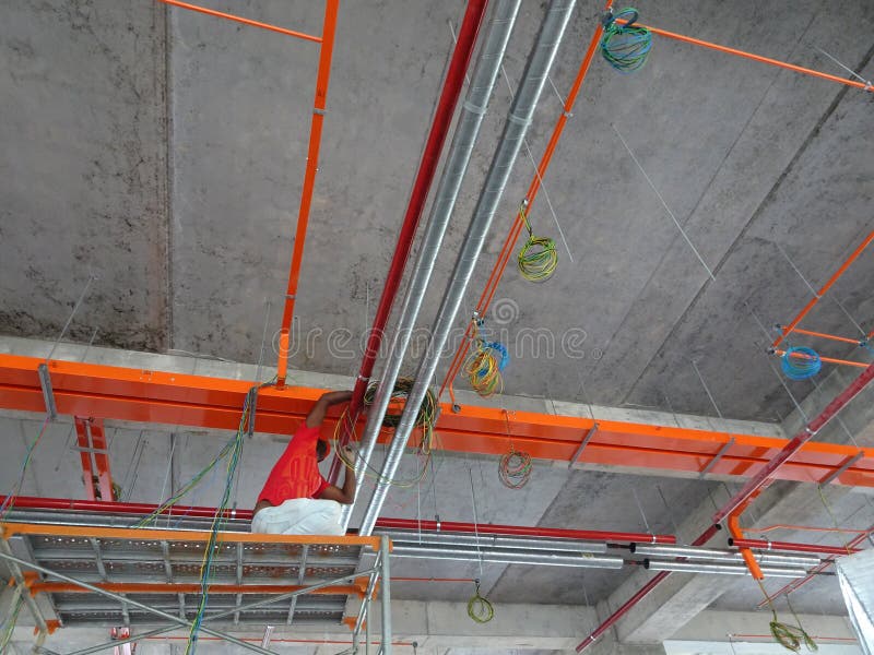 Construction Workers Installing Electrical Cable Tray and Doing Wiring ...