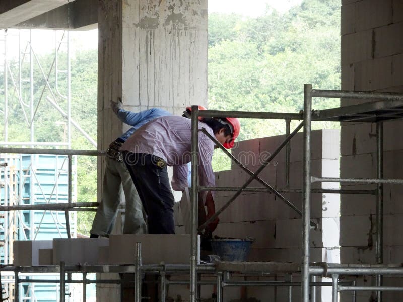 Construction Workers Installing Lightweight Block Bricks To Become Wall ...