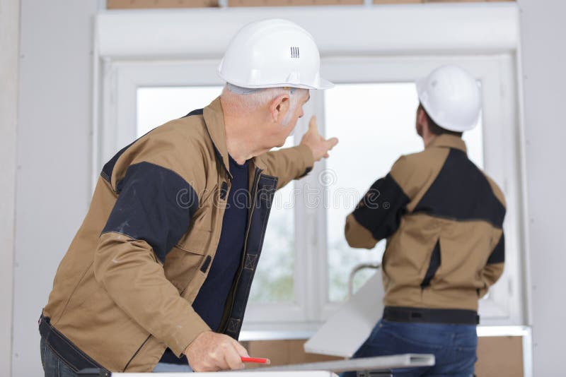 Construction Workers Installing Window in House Stock Photo - Image of ...
