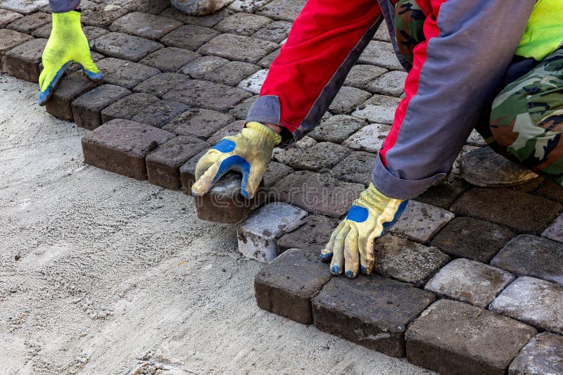 Construction Workers Laying Cobblestone Pavement by Hand. Workers in ...