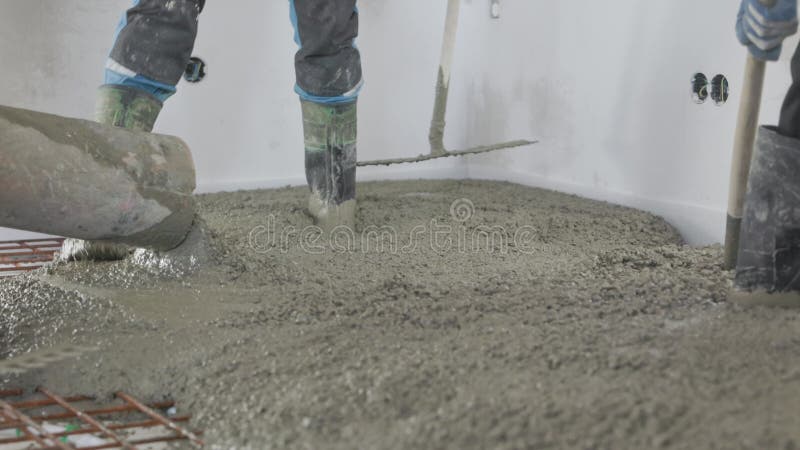 Construction Workers Leveling Concrete Floor Using Shovel and Rake ...