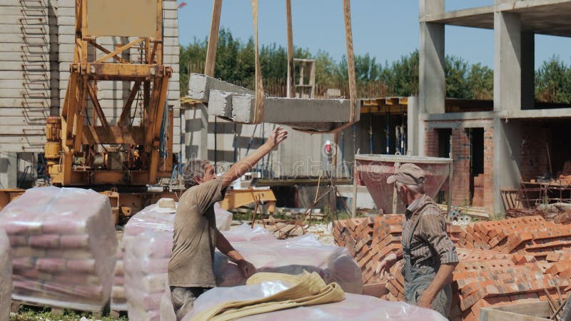 Construction Workers Lifting Heavy Materials on Site. Two Construction ...