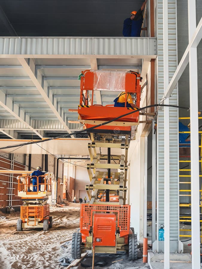 Construction Workers on Lifts Inside a Building during the Build ...