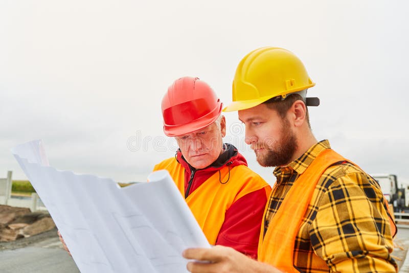 Construction Workers Look at a Construction Plan Together Stock Image ...