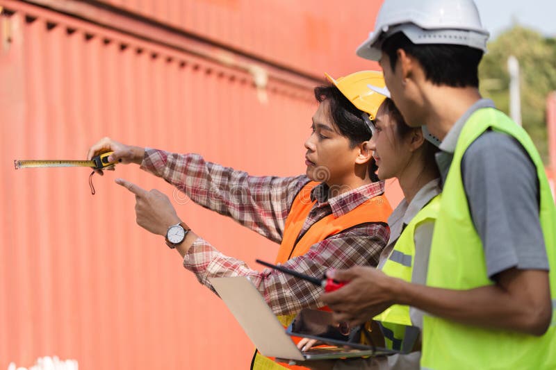 Construction Workers Measuring and Discussing Project Details ...