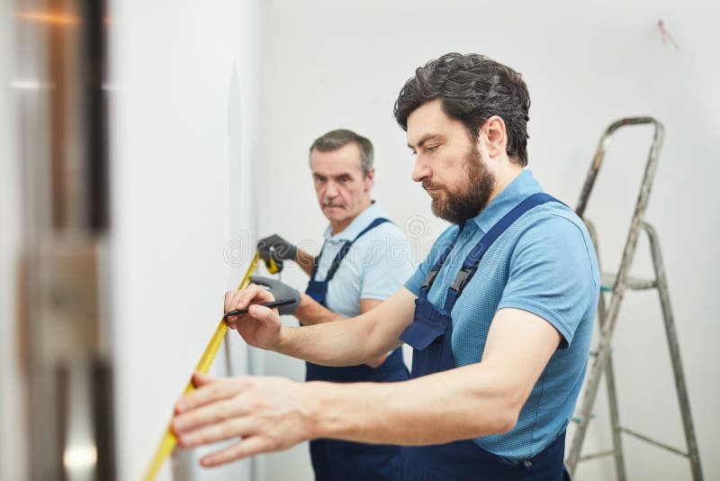 Construction Workers Measuring Wall Stock Photo - Image of skill ...