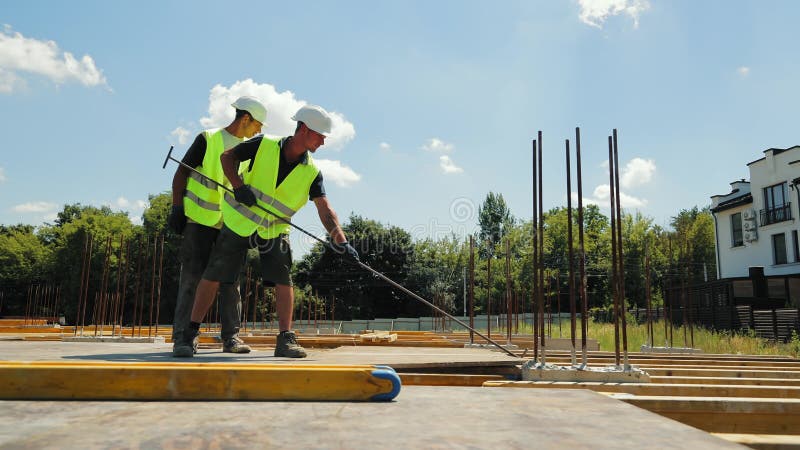 Construction Workers Positioning Large Board on Site. Two Construction ...