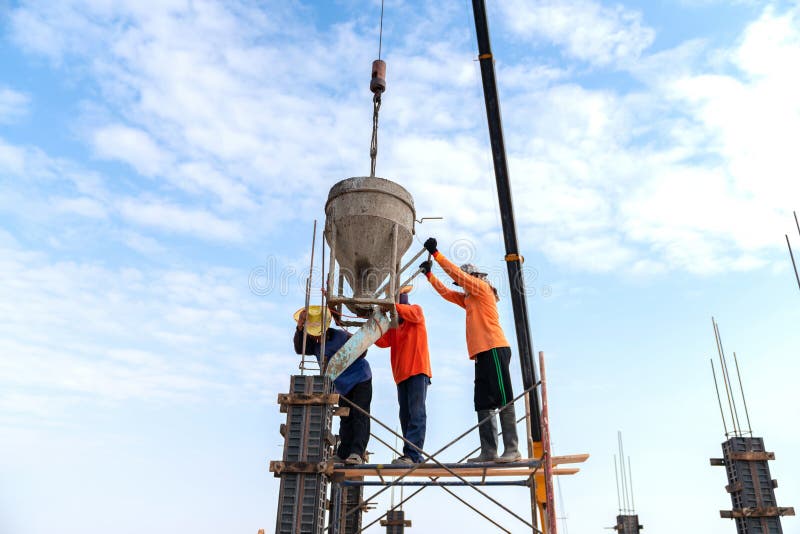 Construction Workers Pour Concrete Column at the Construction Site ...