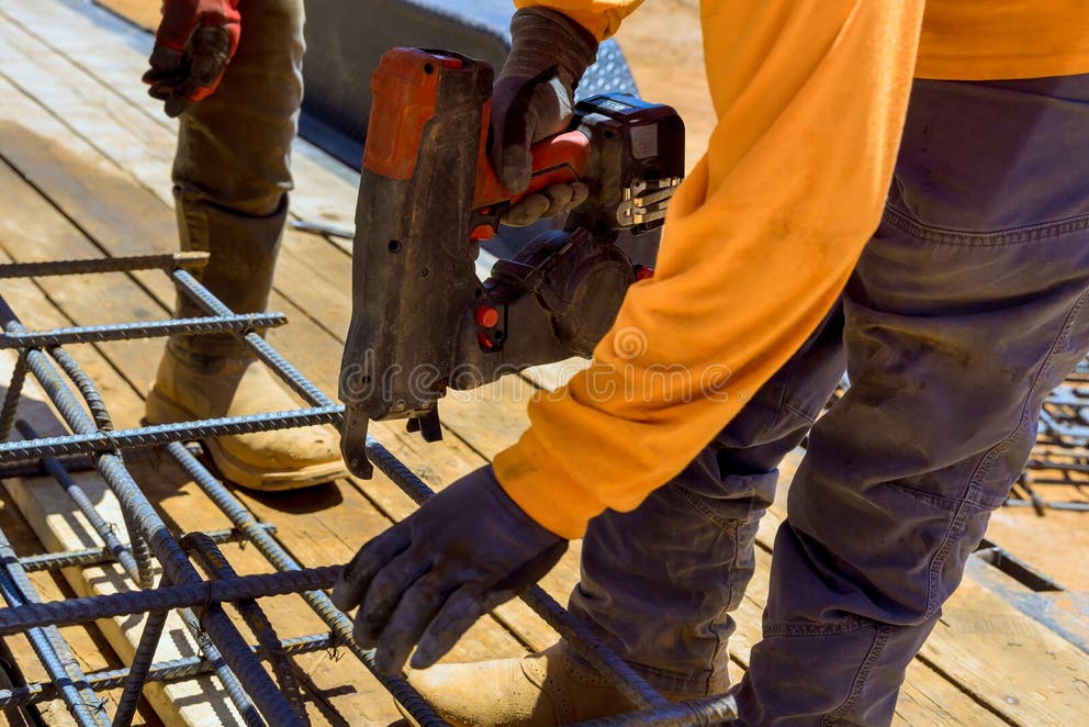 Workers Using Power Tool To Secure Rebar in Construction Site during ...
