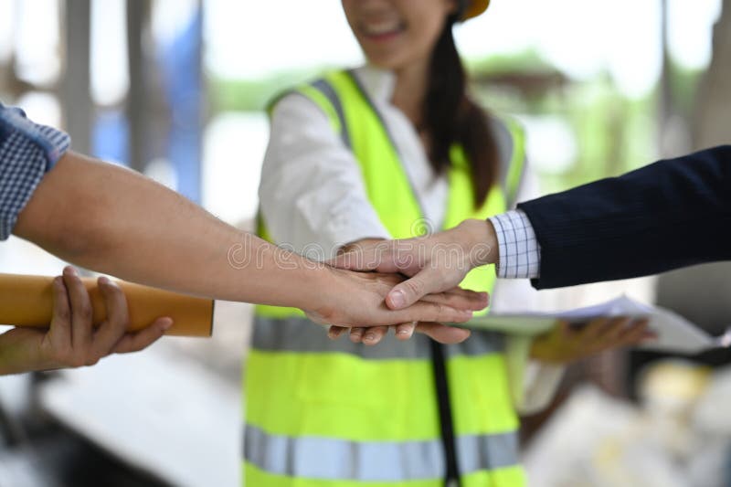 Construction Workers Stacking Hands To Motivate and Working As Teamwork ...