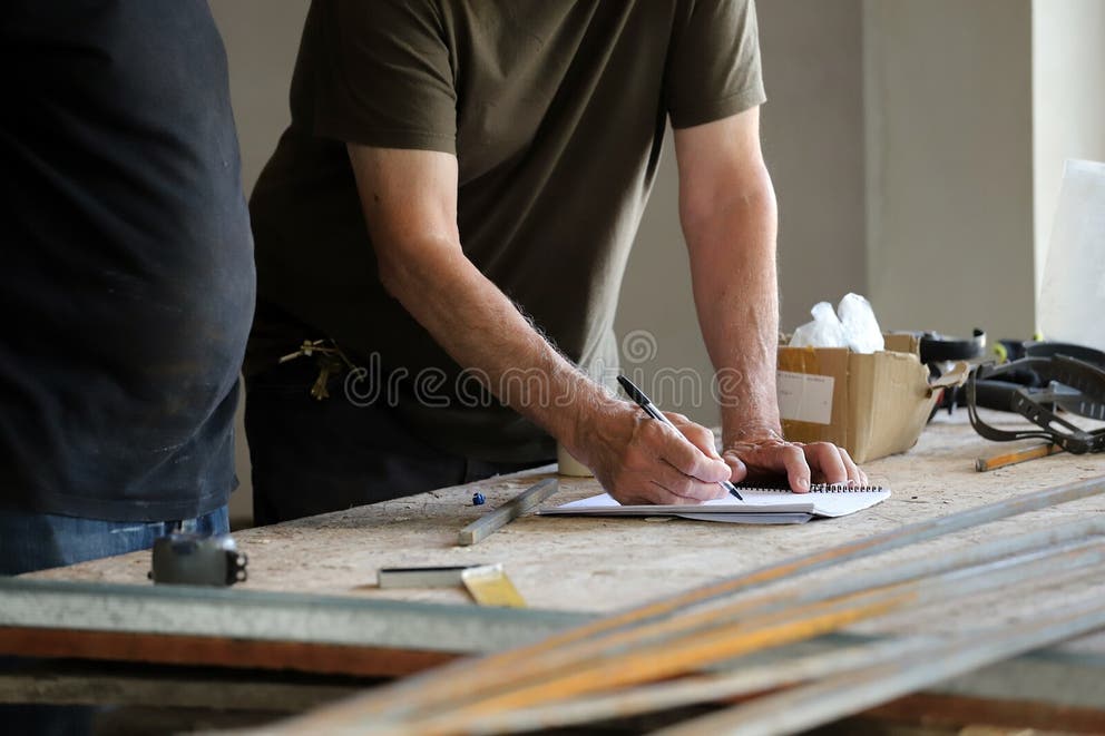 Construction Workers Taking Notes on Papers while Projecting ...