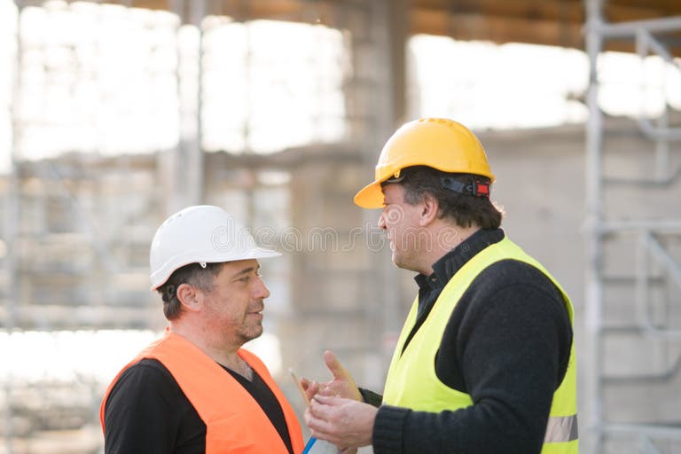 Construction Workers Talking on Construction Site Stock Photo - Image ...