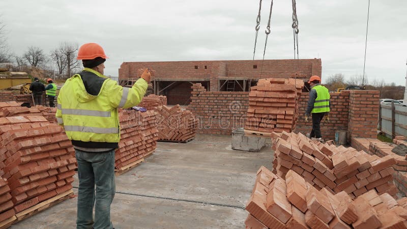 Construction Workers Unloading Bricks on Site, a Group of Construction ...