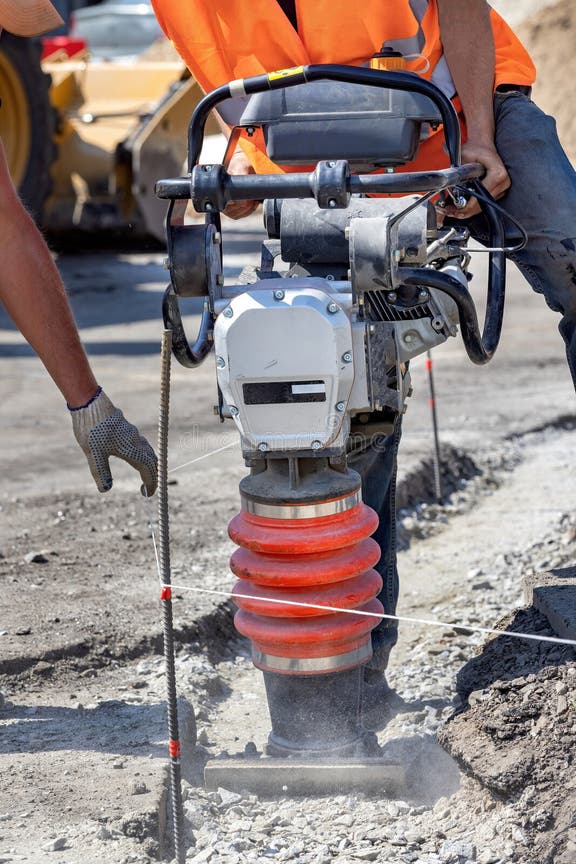 Construction Workers Using a Compactor To Prepare Ground for Building ...