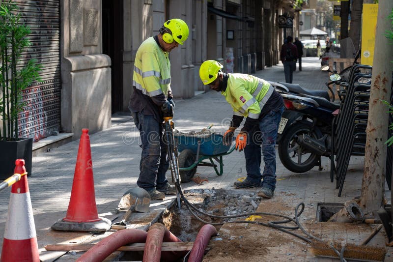 Construction Workers Using Pneumatic Hammer for Underground Pipe Repair ...