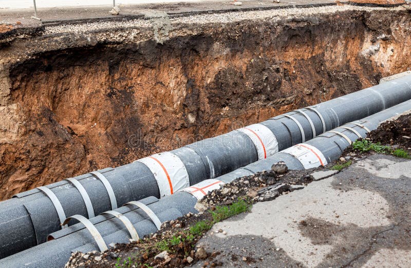 Construction Works on Large Iron Pipes at a Depth of Excavated Trench ...