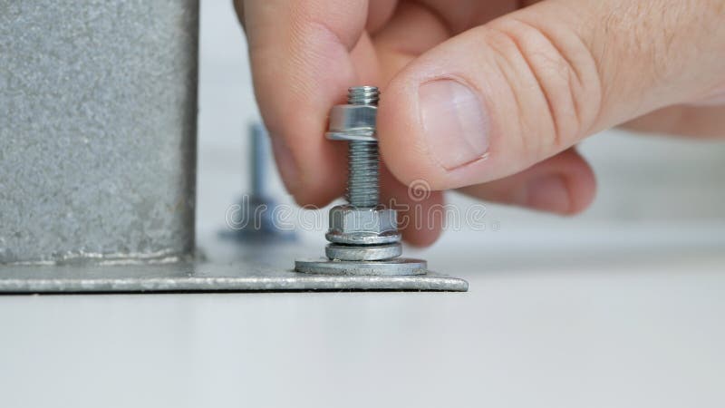 Constructor Screwing a Nut Onto a Metal and Tightly Secure a Part of a ...