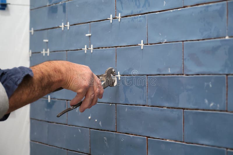 Constructor Worker Hand Removing the Separation between Tiles on the ...