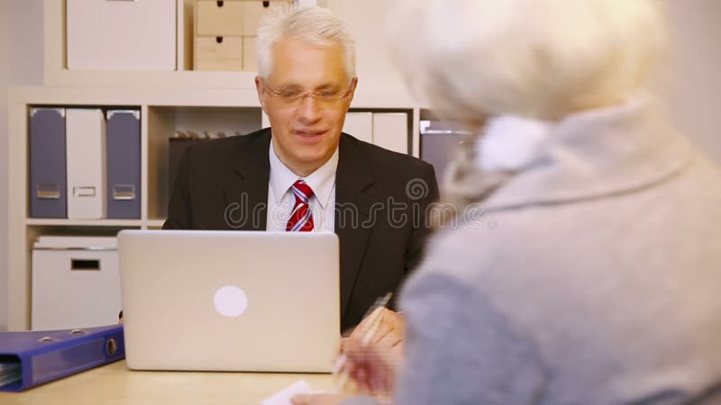 Consultant Talking To Elderly Customer in Office Stock Video Footage ...