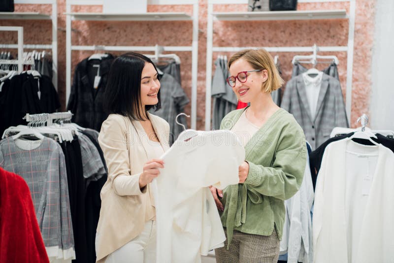 Consultor De Moda Que Muestra La Ropa Al Cliente Imagen de archivo ...
