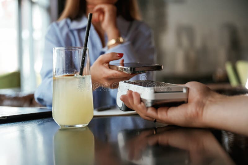 Contactless Transfer. Woman is Paying for the Service in the Restaurant ...
