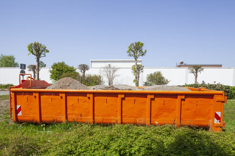 Container, Orange Skip for Building Rubble Standing on a Meadow Stock ...
