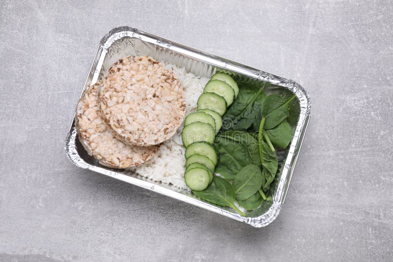 Container with Rice, Puffed Crunchy Cakes. Fresh Spinach and Cut ...