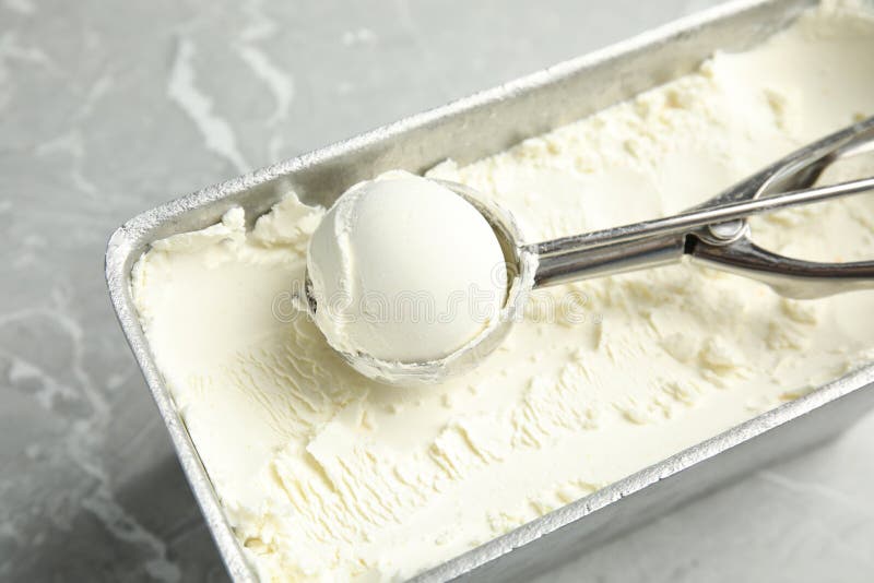 Container and Scoop with Delicious Vanilla Ice Cream on Table Stock ...