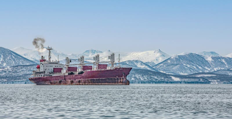 Container Ship in the Bay Opposite the Snow-capped Mountains on the ...