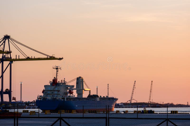 Container Ship with Cranes for Loading Goods in the Port in the Evening ...