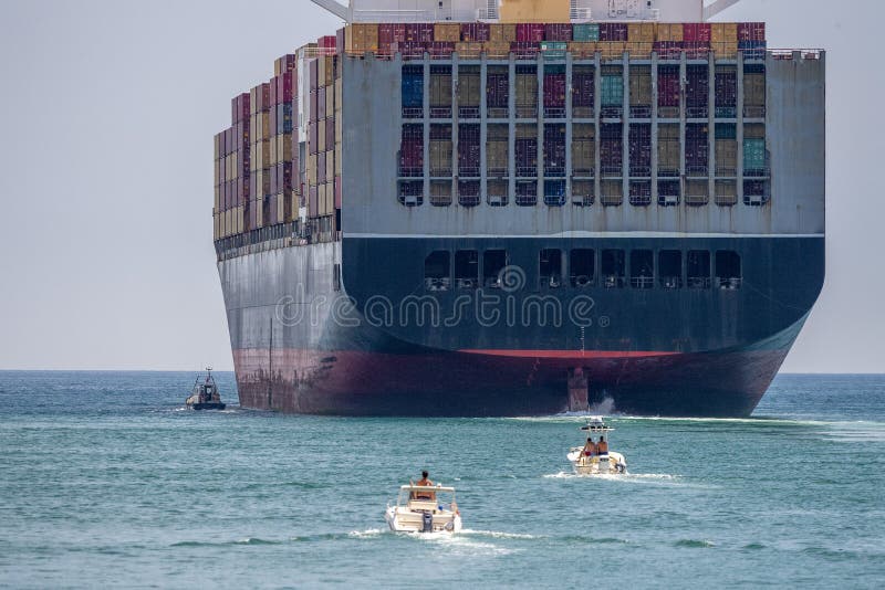 Container Ship Near the Coast with Tugboat and Small Vessels Stock ...