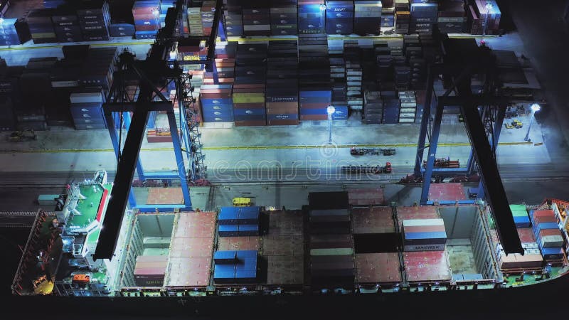AERIAL Unloading of Containers at Night in the Port. Container Terminal ...