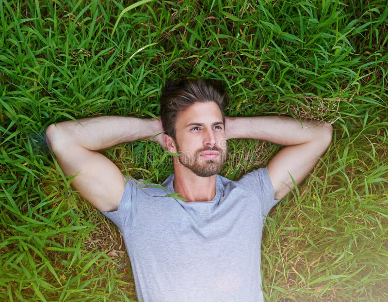 Contemplating Life. High Angle Shot of a Young Man Lying Down on the ...