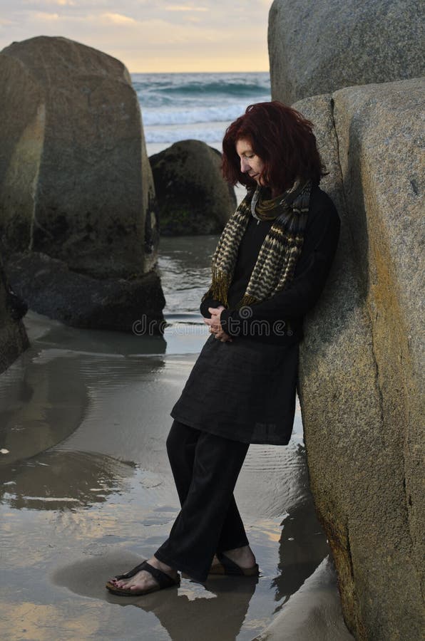 Contemplative Woman by Seaside Rocks Stock Photo - Image of ...