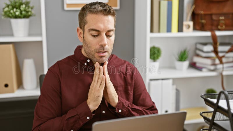 A Contemplative Young Hispanic Man with a Beard in an Office Setting ...