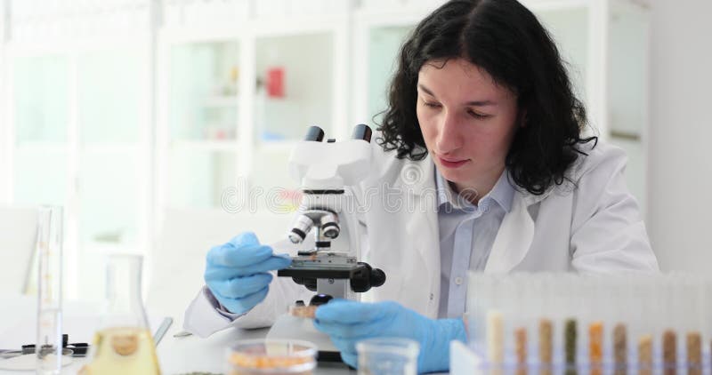 A Scientist Meticulously Analyzes a Sample Under a Microscope in the ...
