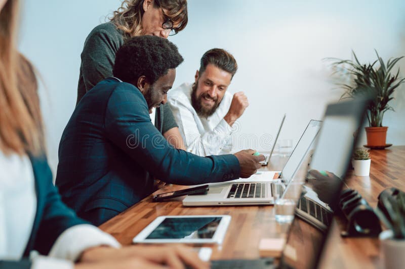 Content Diverse Coworkers Examining Papers Near Laptops Stock Photo ...