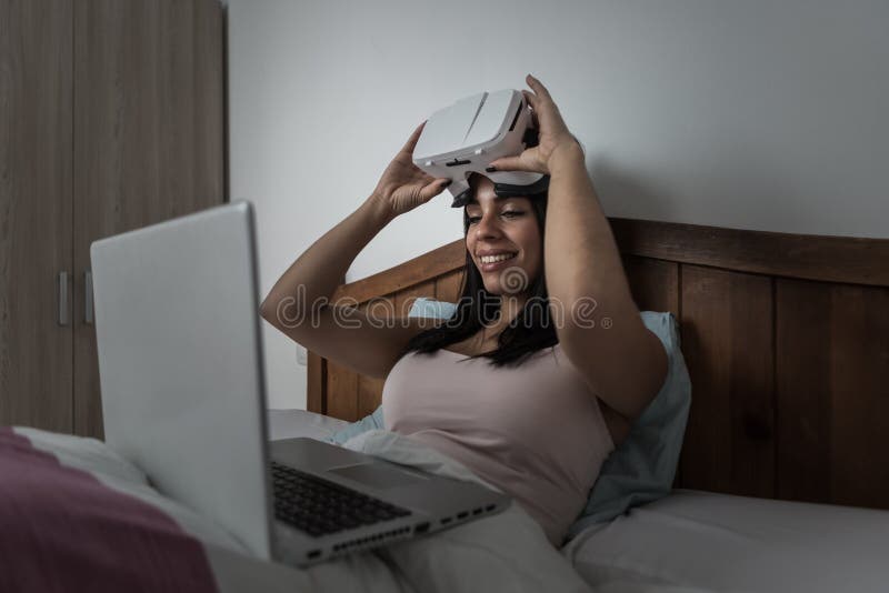 Woman Using VR Goggles and Laptop on Bed Stock Image - Image of home ...