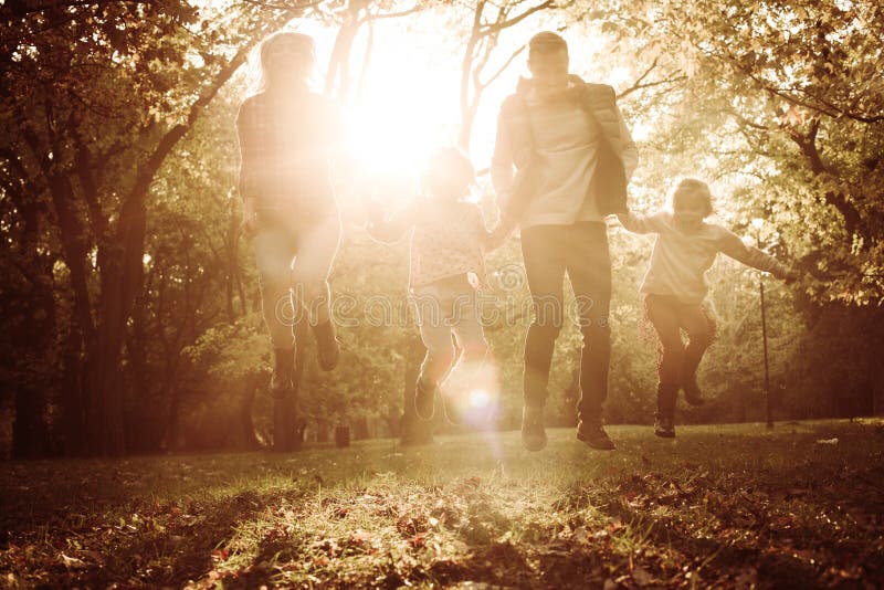 Content Happy Family Jumping High in Park. Stock Photo - Image of ...