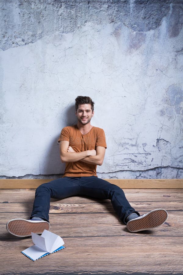 Content Man Sitting Against Wall Stock Image - Image of space, cool ...