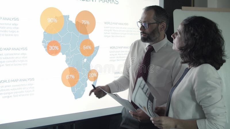 Content Manager Pointing on Map and Talking with Businesswoman Stock ...