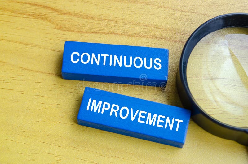 Continuous Improvement Text on Blue Wooden Blocks with Magnifying Glass ... Continuous Improvement Text on Blue Wooden Blocks with Magnifying Glass ...