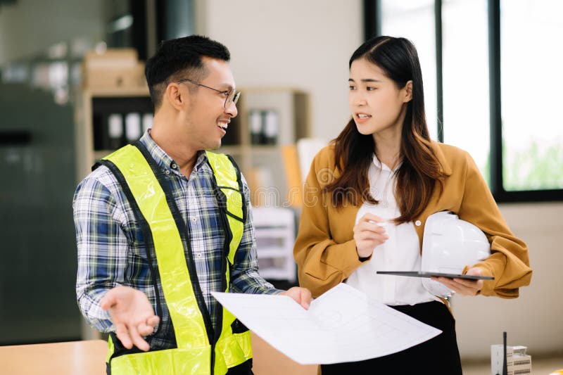 Contractor and Architect Looking at Plan, Tablet, Laptop and Talking ...