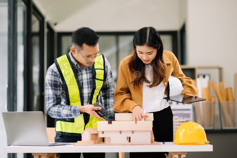 Contractor and Architect Looking at Plan, Tablet, Laptop and Talking ...