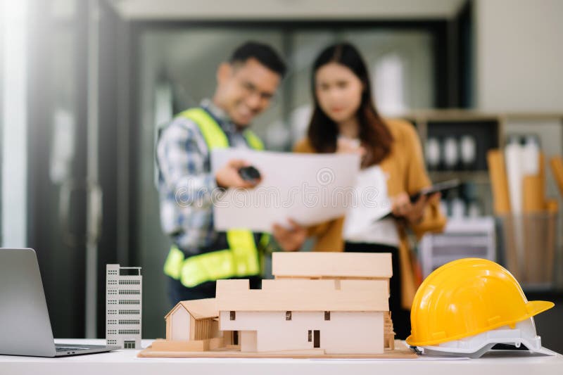 Contractor and Architect Looking at Plan, Tablet, Laptop and Talking about Working on Big ...