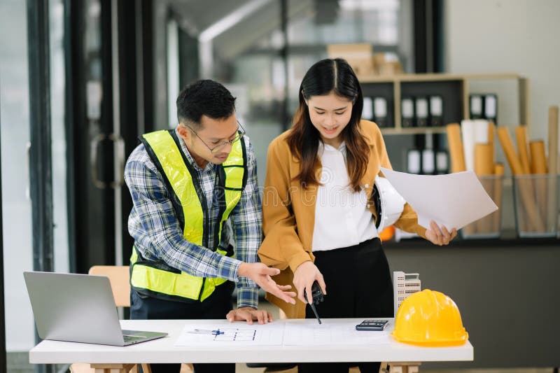 Contractor and Architect Looking at Plan, Tablet, Laptop and Talking ...