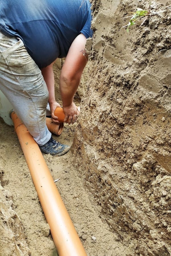 The Contractor Installs a Sewer in a Ditch and Leads the Pipe To the ...