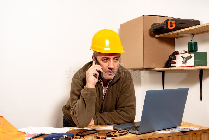 Contractor Talking on Cell Phone with Laptop in Front of Work Office ...