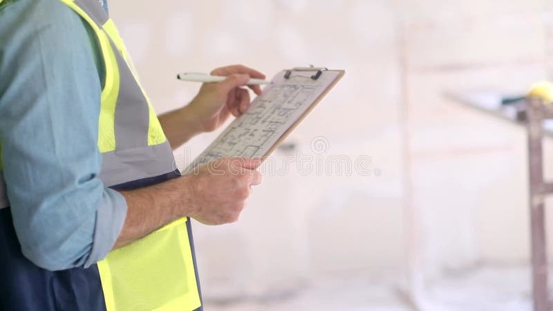 Contractor in Vest Checking Renovation Project Plan on Clipboard in ...